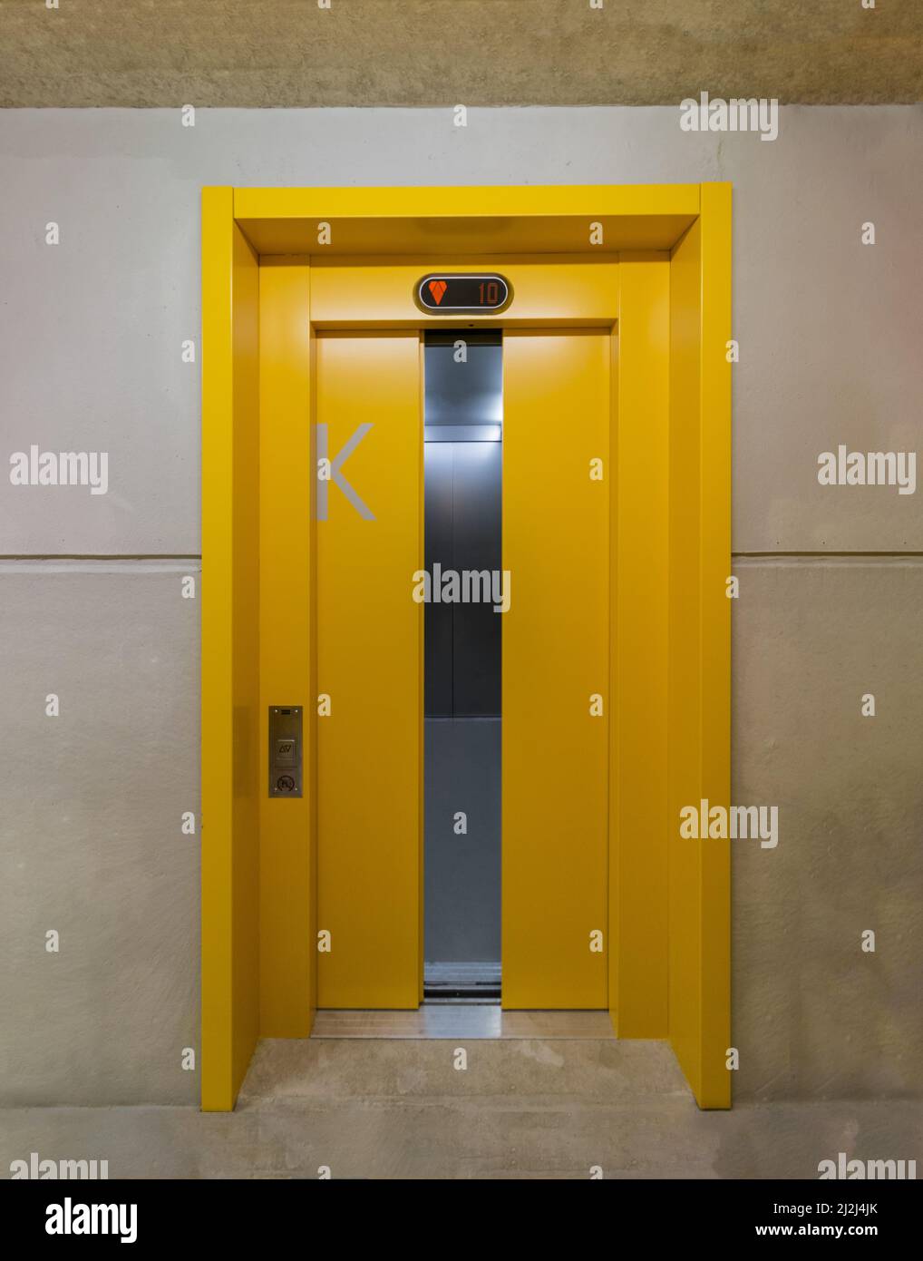 A shot of a yellow door of elevator with letter K on it Stock Photo - Alamy