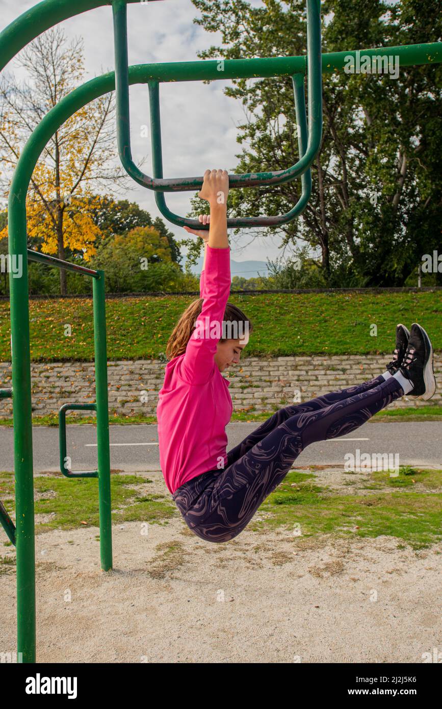 Attractive and beautiufl fit girl is trying to hold her legs up while ...