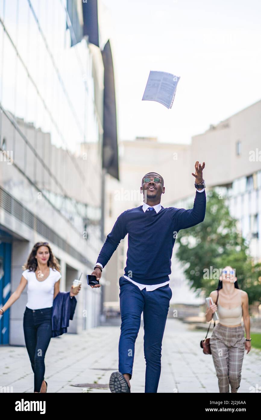 Three multiracial business co workers are acting crazy while walking ...