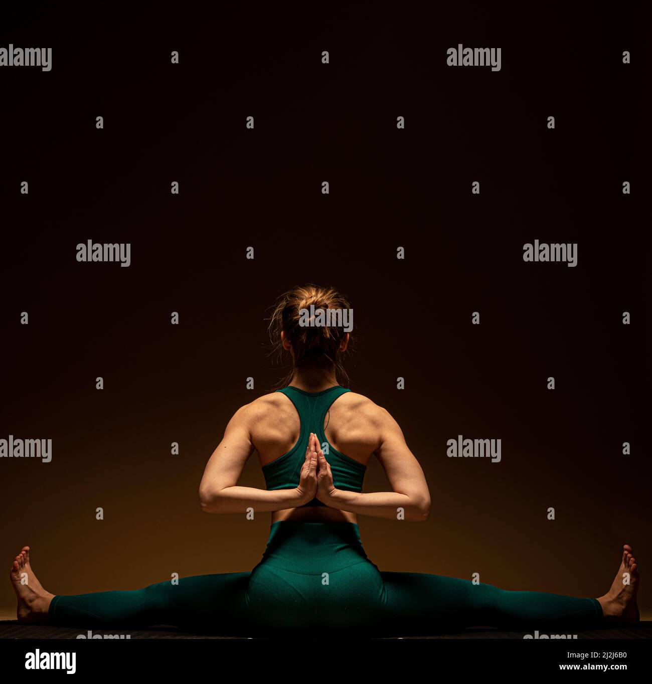 Attractive and beautiful young girl is doing splits on the ground and ...