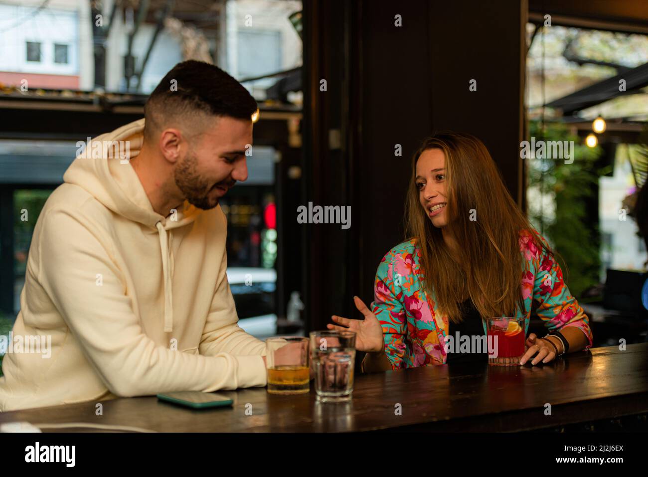 Attractive and handsome young guy is flirting with the girl while ...