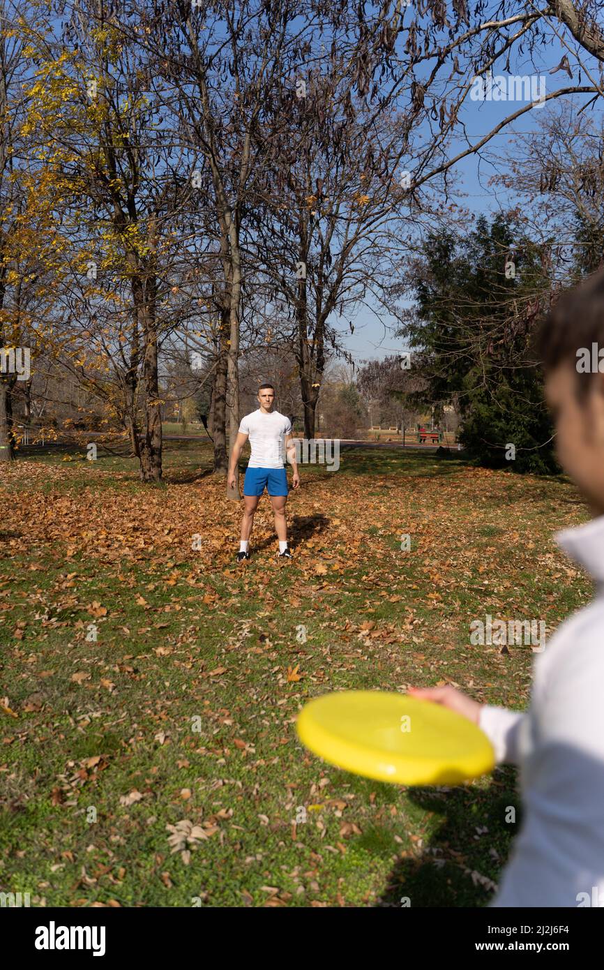 Two attractive and amazing fit friends are playing frisbee outside ...