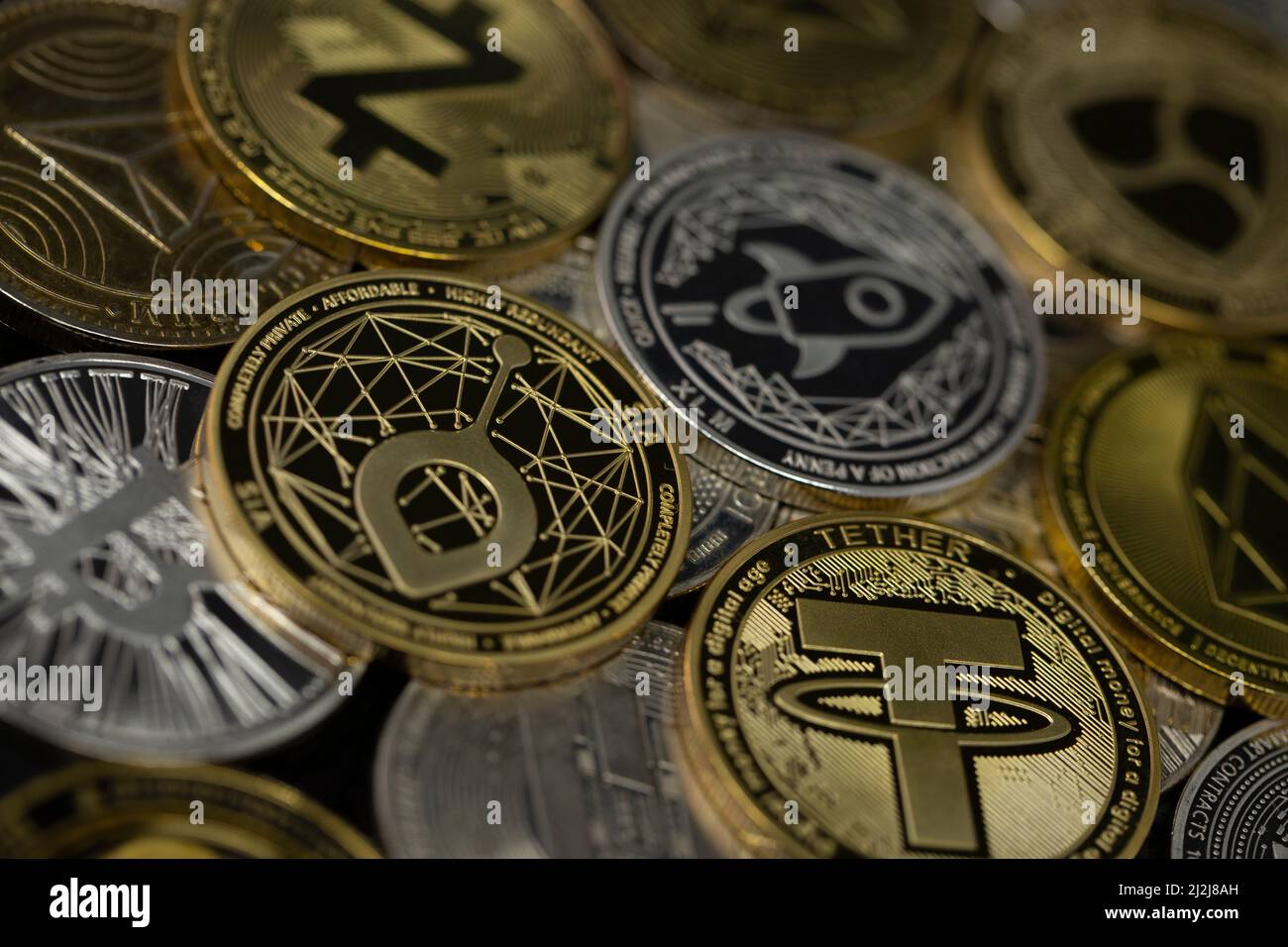 Variety of cryptocurrency physical coins placed on the black surface ...