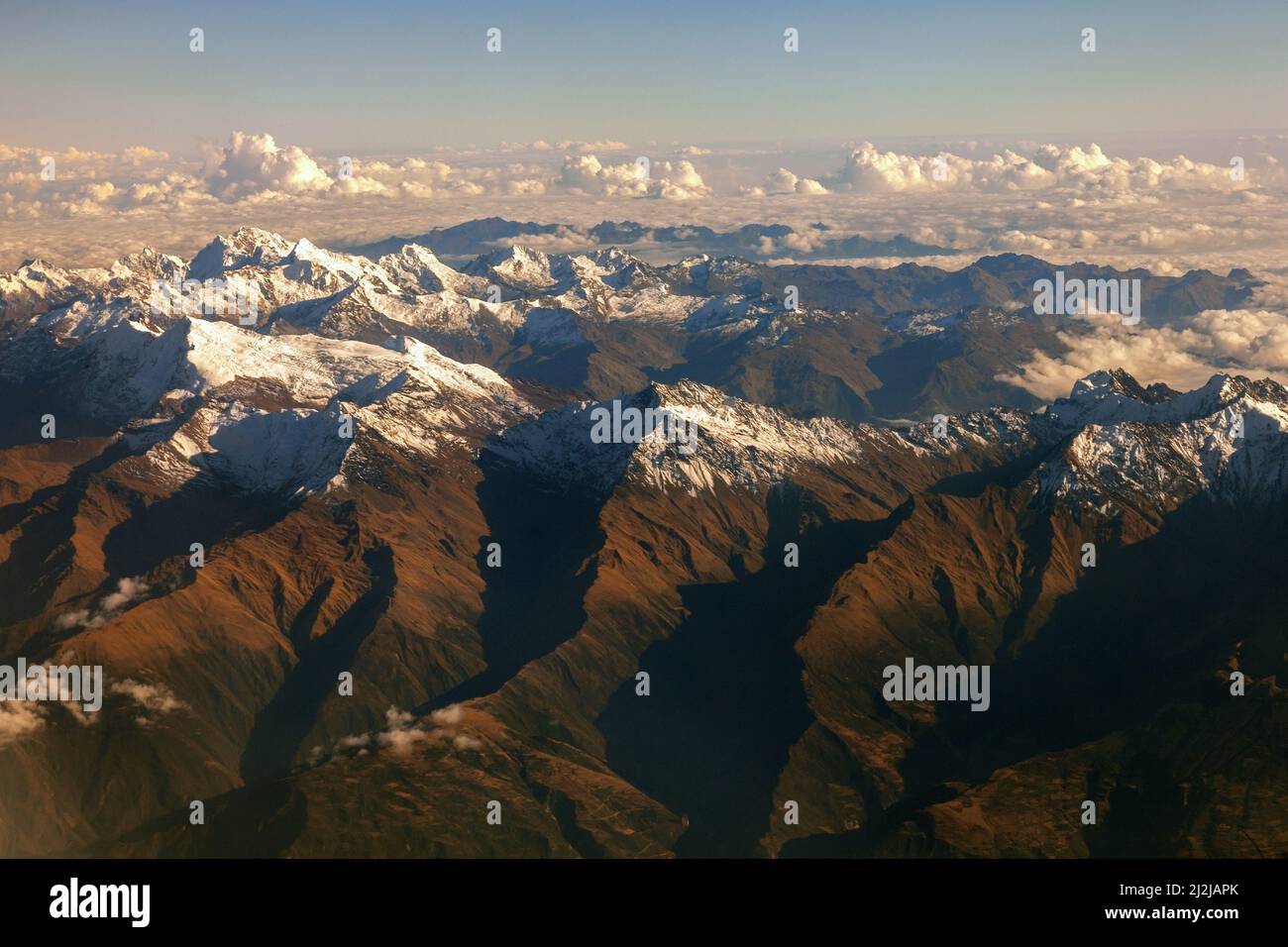 An aerial view of the beautiful, rocky Andes mountains with snowy tops ...