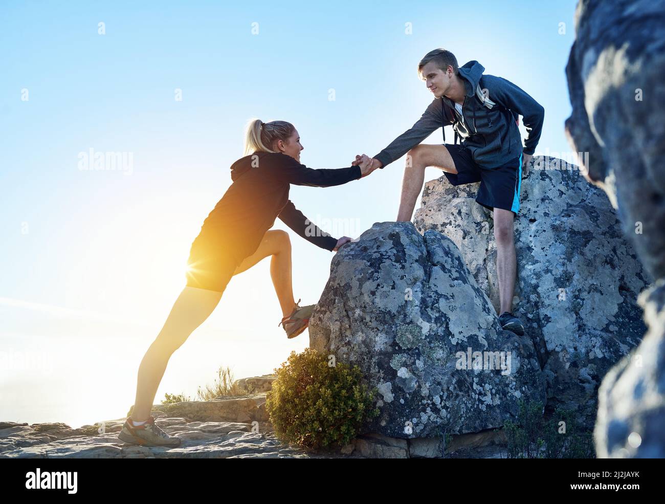 To the top, together. Full length shot of a young man helping his ...