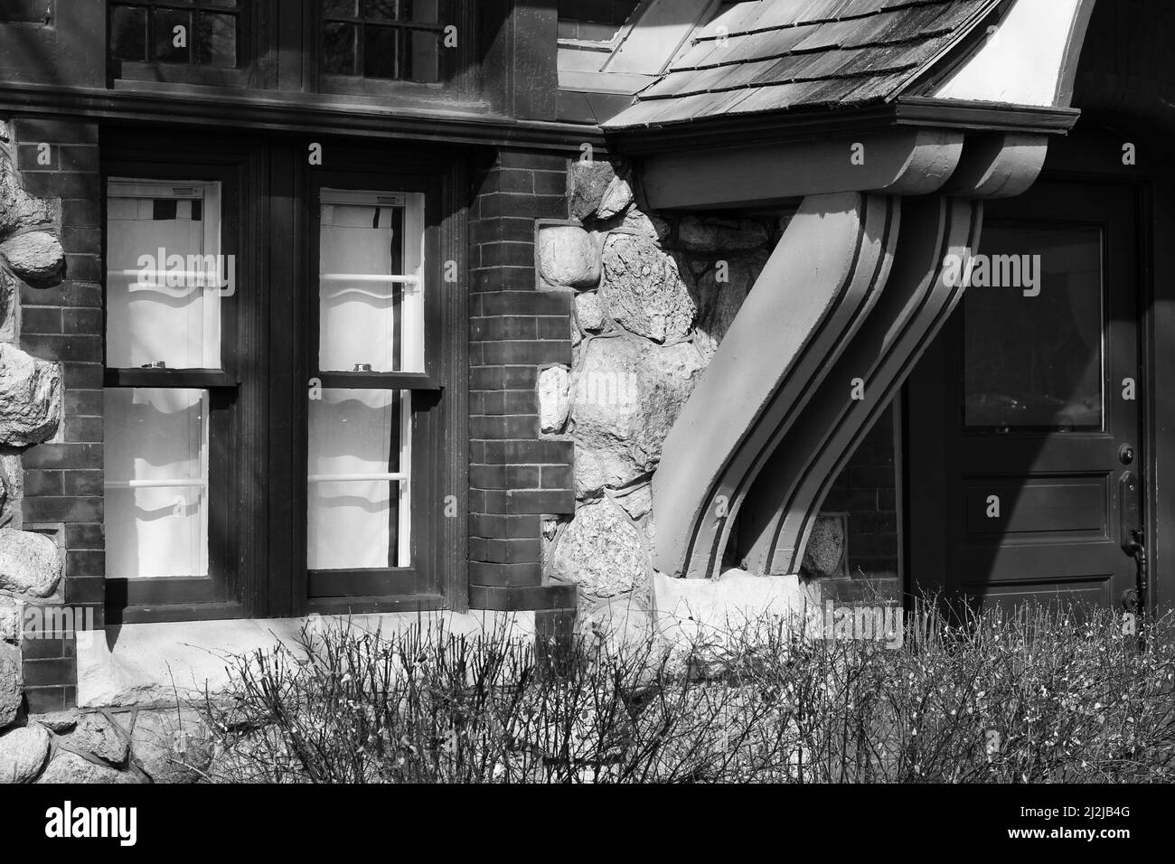 Vintage wooden windows on a charming rustic stone cottage in black and ...