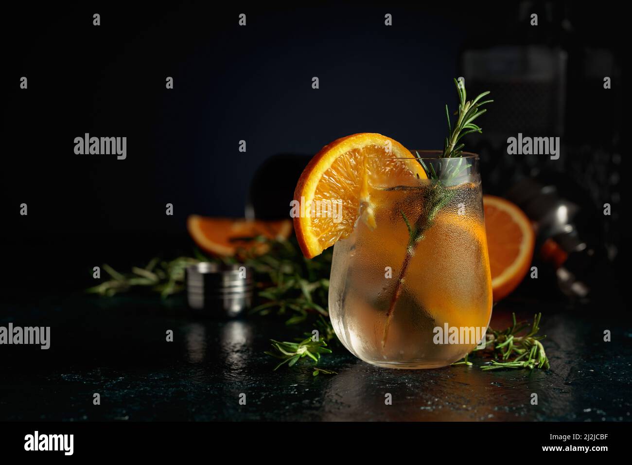 Cocktail gin tonic with ice, orange, and rosemary. Refreshing drink ...