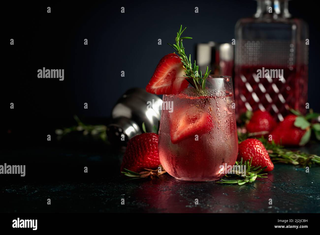 Cocktail gin tonic with ice, strawberries, and rosemary. Refreshing ...