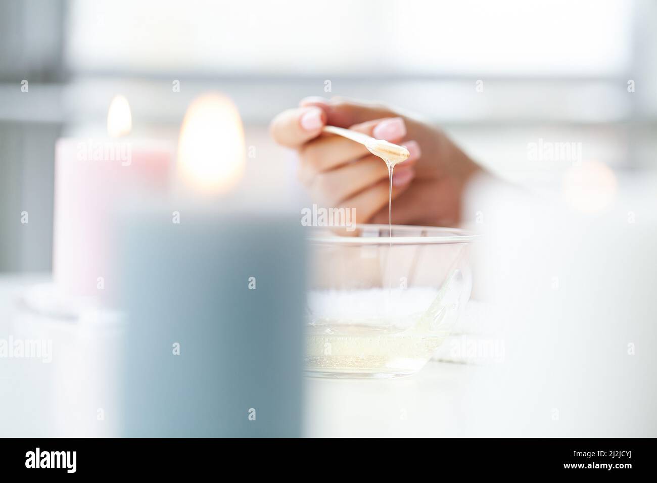 Young woman with beautiful hands putting some wax on them to remove all ...