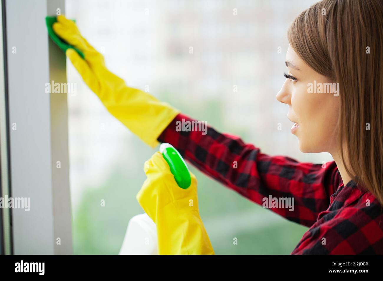 Happy young woman housewife washes a window Stock Photo - Alamy