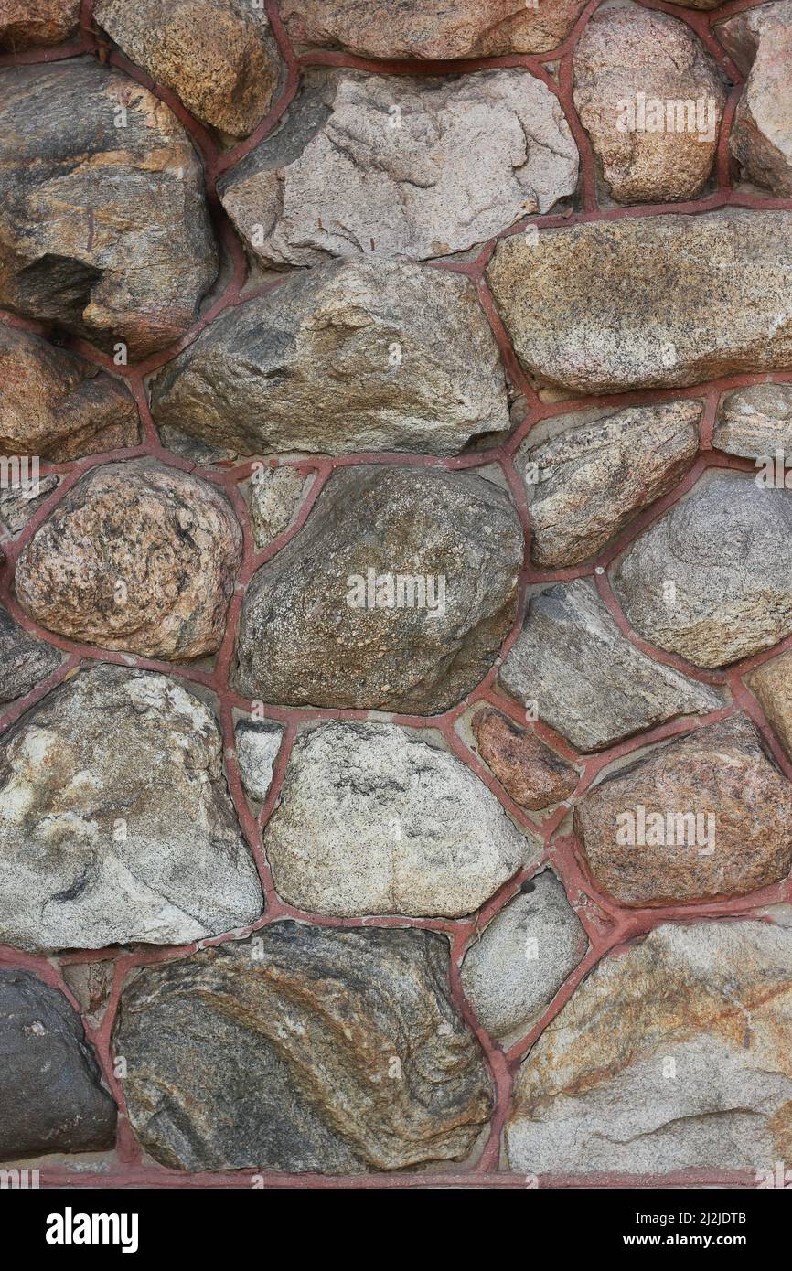 Rustic stone wall built with round boulders and granite stones Stock ...