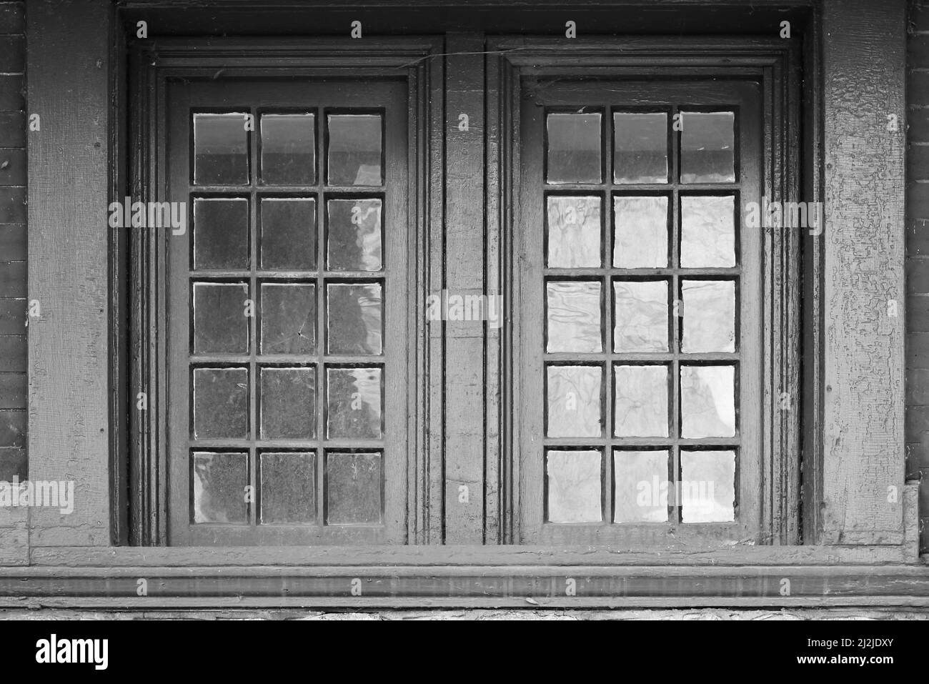 Vintage wooden windows on a charming rustic stone cottage in black and ...