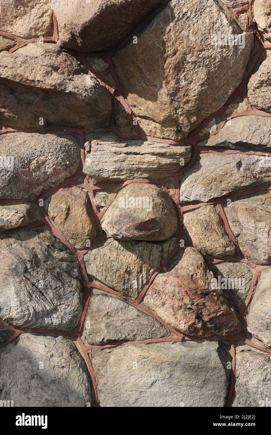 Rustic stone wall built with round boulders and granite stones Stock ...
