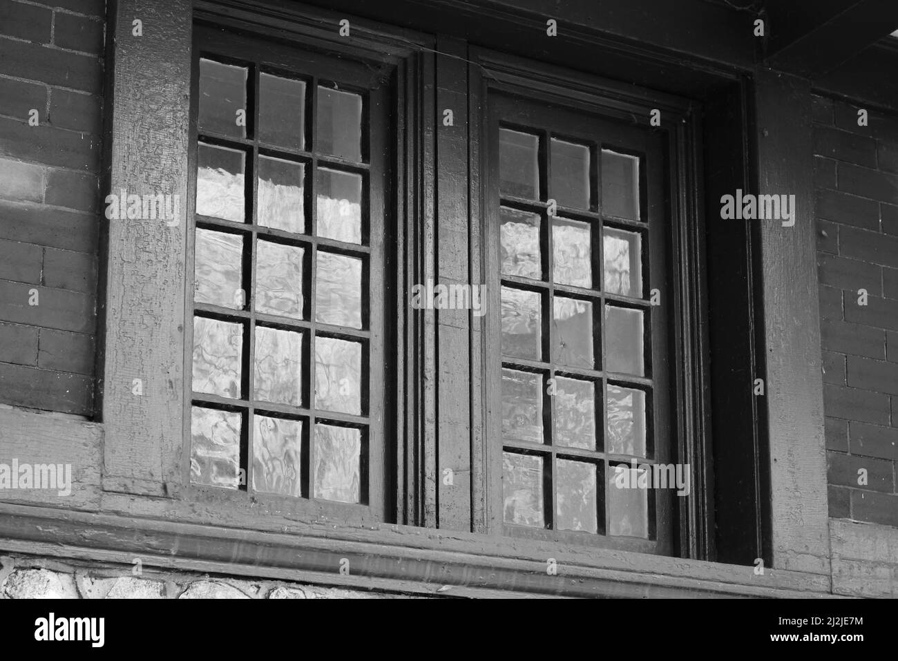 Vintage wooden windows on a charming rustic stone cottage in black and ...