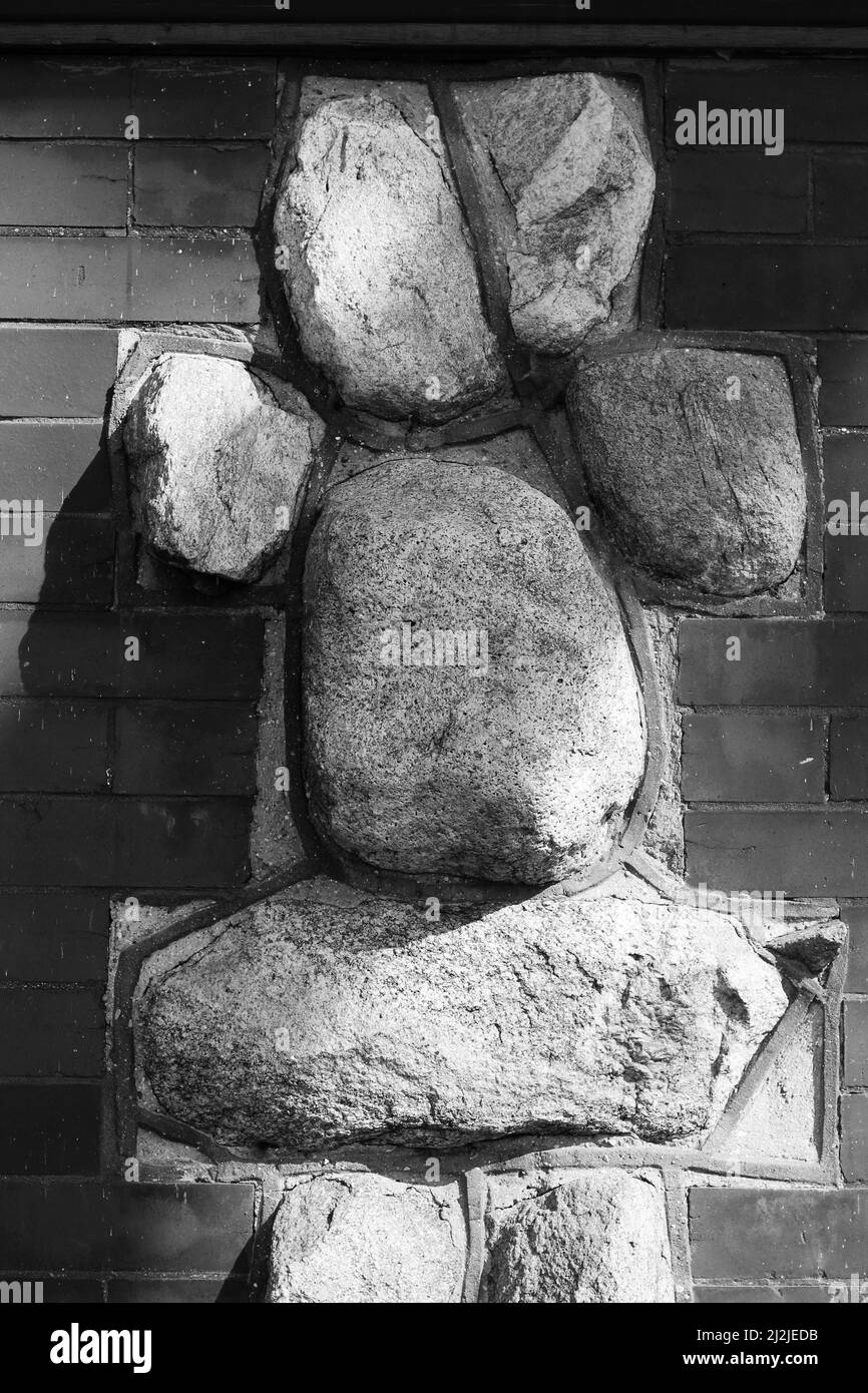 Rustic stone wall built with round boulders and granite stones in black ...