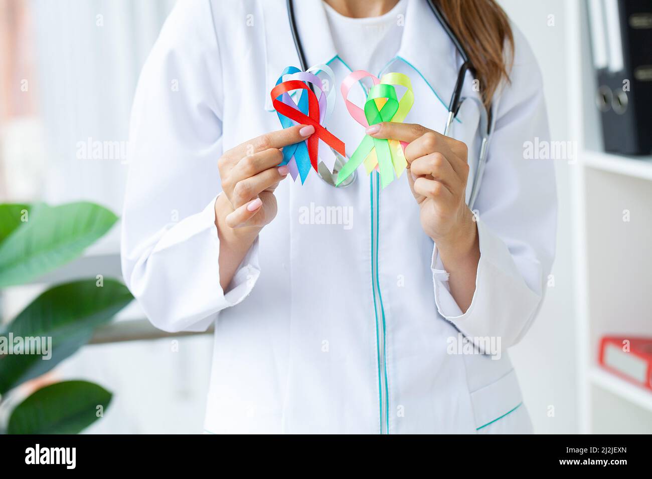 Female doctor holds colored ribbons symbolize awareness of various ...