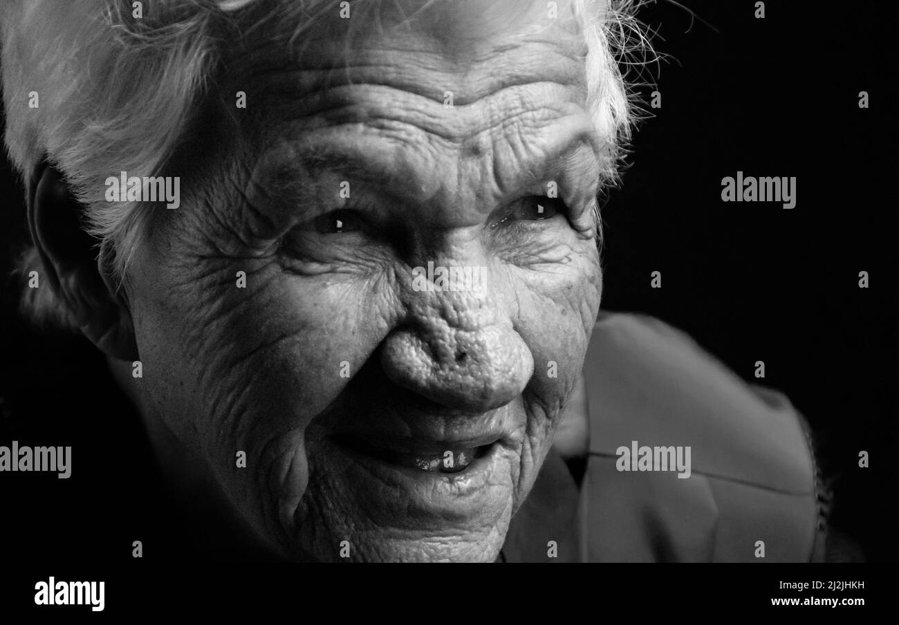 Portrait of serious senior woman against black background. Black and ...