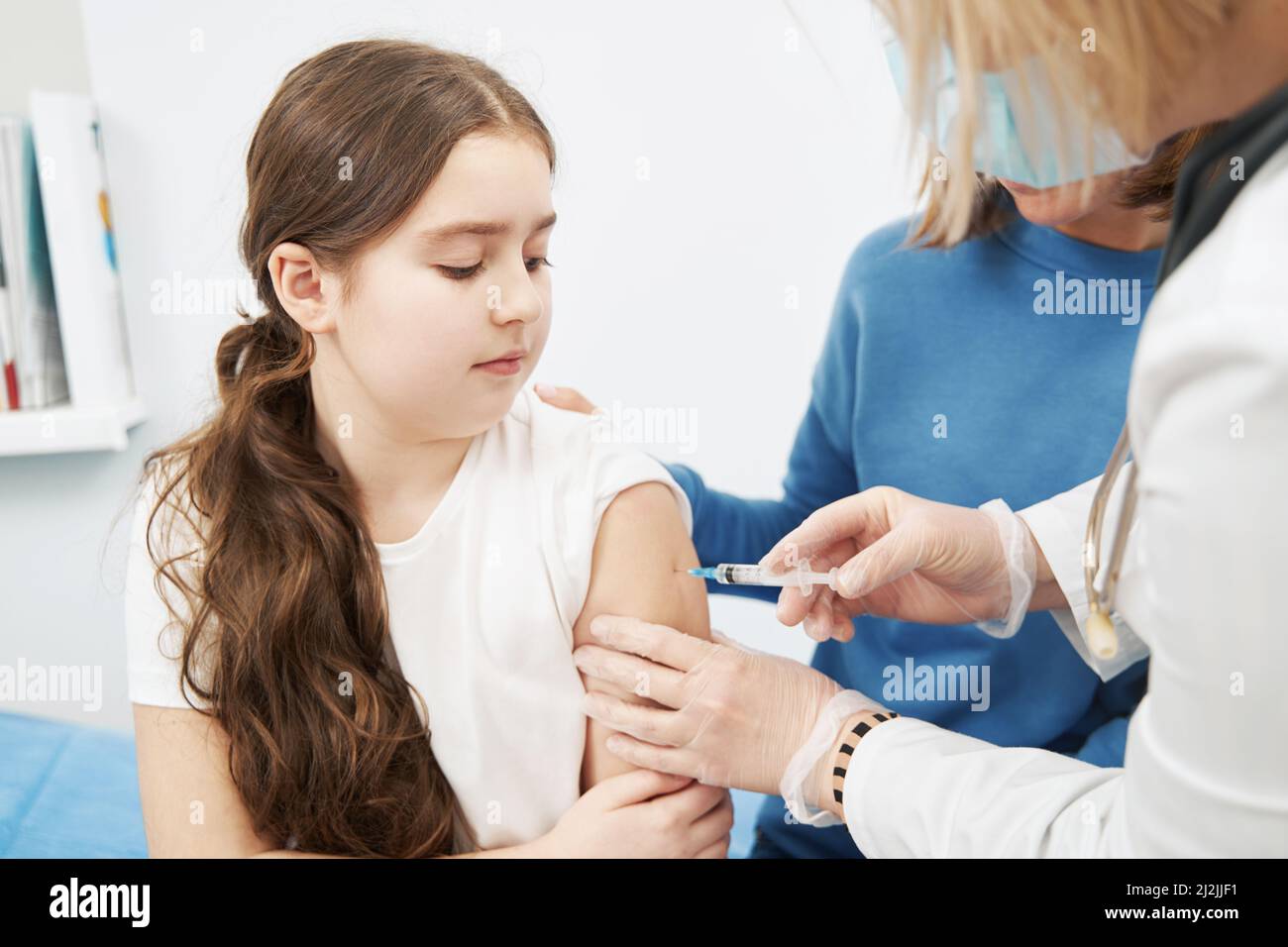 Little girl getting vaccine injection in clinic Stock Photo - Alamy