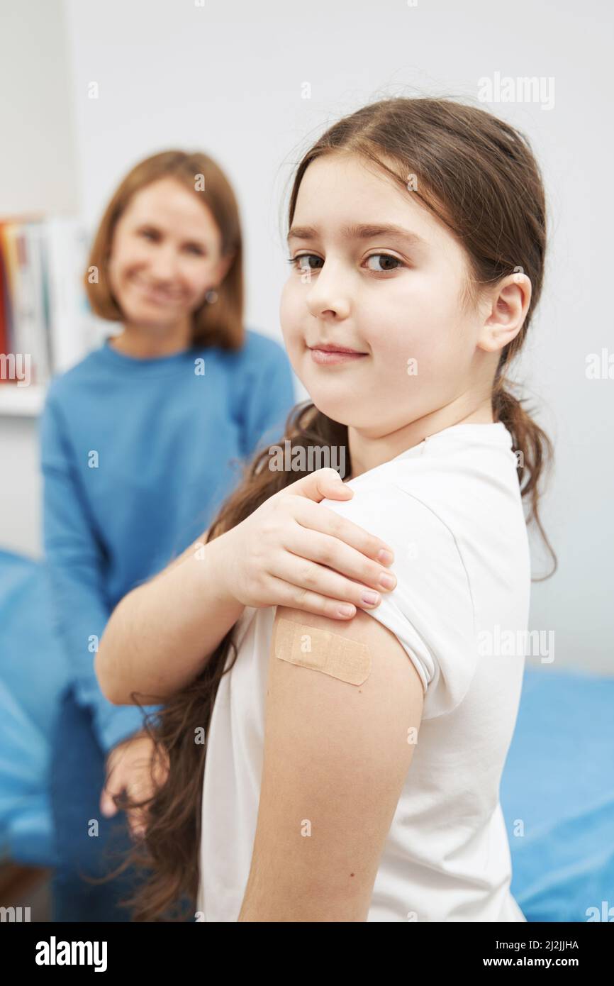 Little girl showing arm after getting vaccine injection in clinic Stock ...