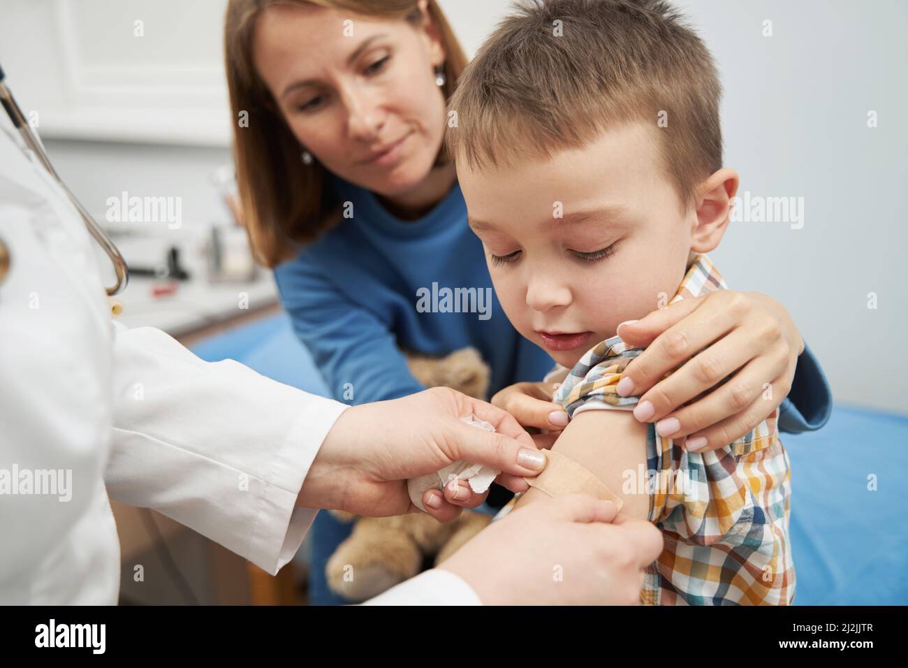 Doctor placing medical plaster on child arm after vaccination Stock ...