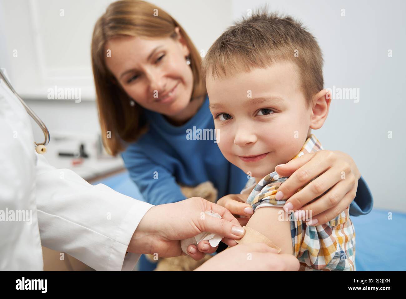 Pediatrician placing medical plaster on child arm after vaccination ...