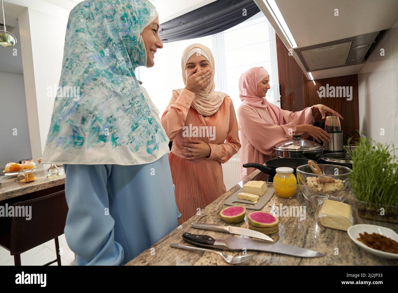 Three Muslim friends having fun while cooking Stock Photo - Alamy