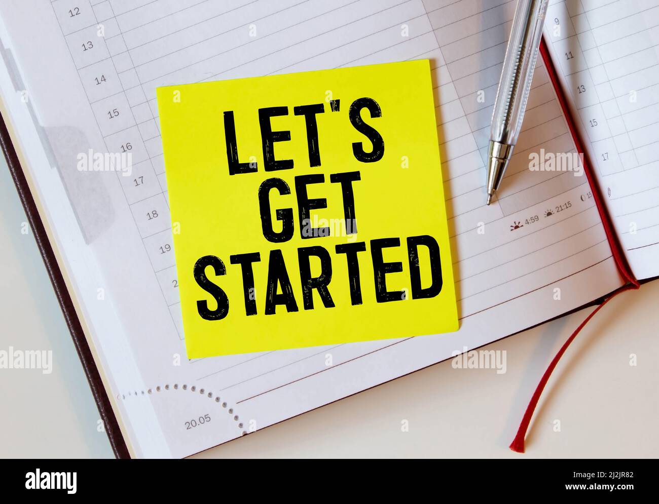 Let's get started word on white ring binder notebook with hand holding ...