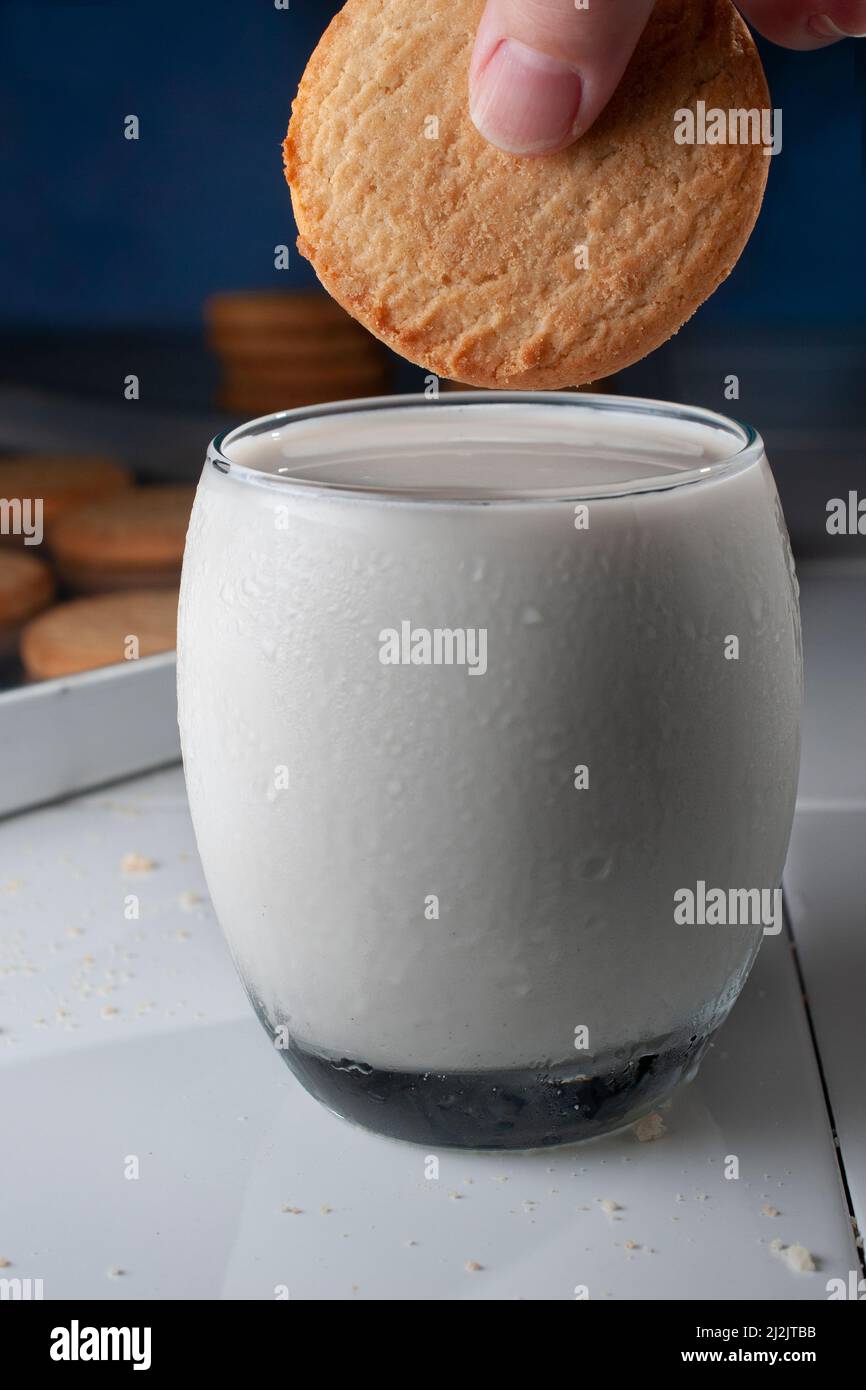 a pile of cookies with a glass of ice milka in a kitchen tray in a dark ...
