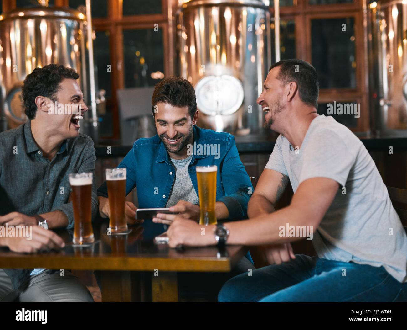 Time to talk business over a beer. Shot of three cheerful young men ...