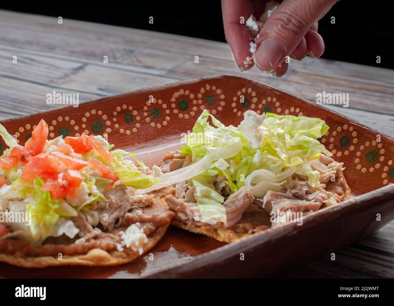 Traditional Mexican food tostadas on a clay or mud plate over a rusic ...