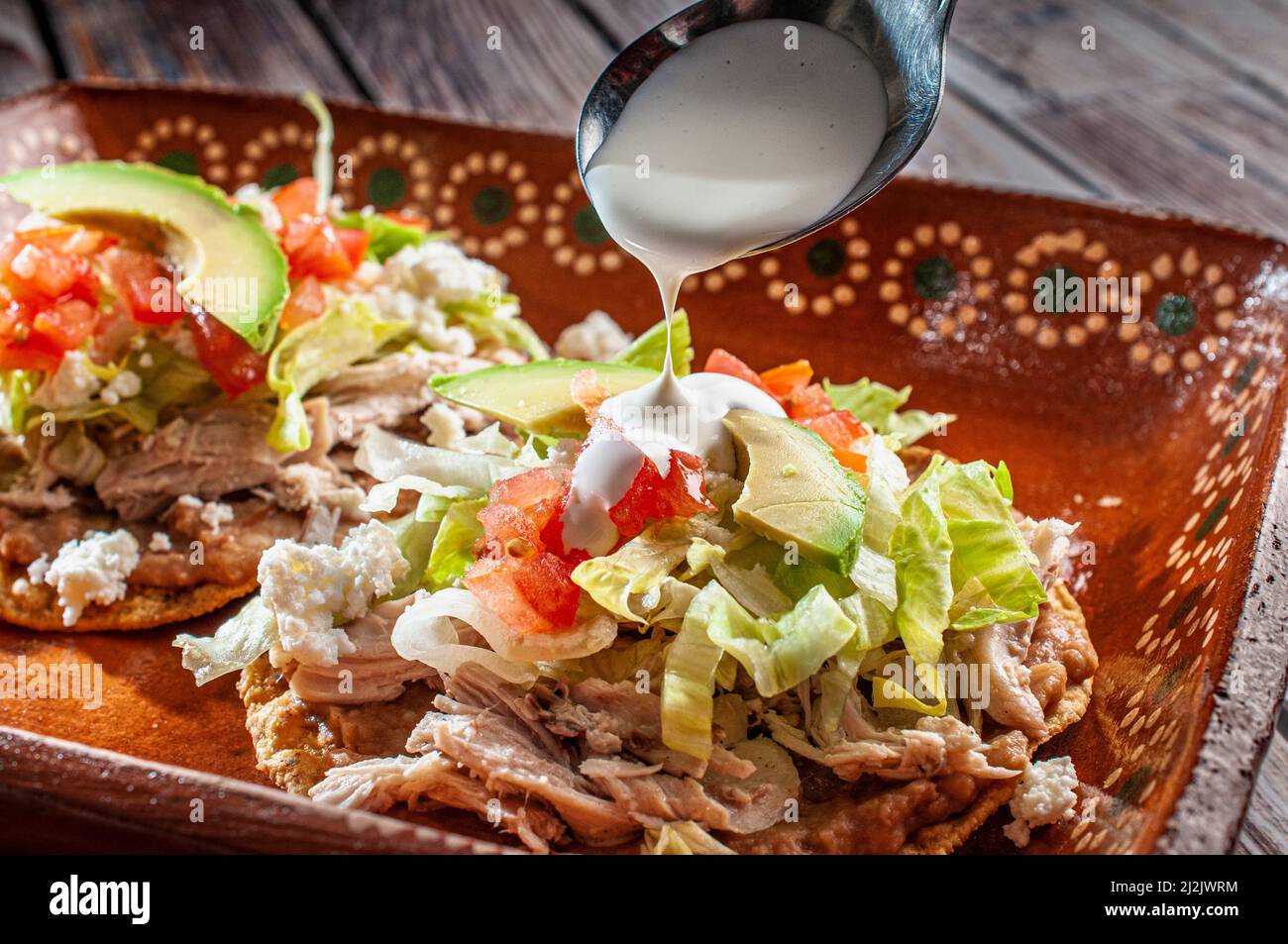 Traditional Mexican food tostadas on a clay or mud plate over a rusic ...