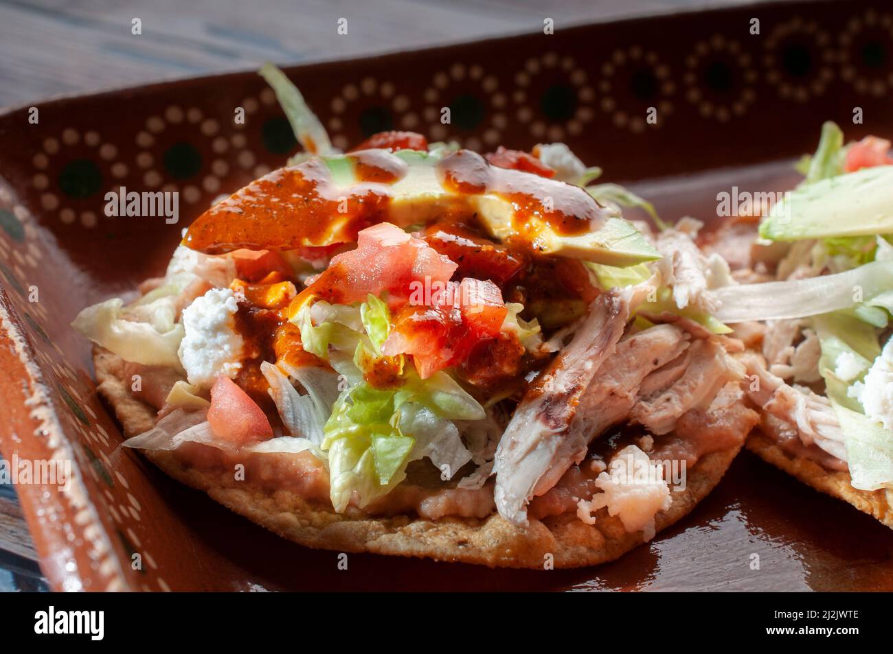Traditional Mexican food tostadas on a clay or mud plate over a rusic ...