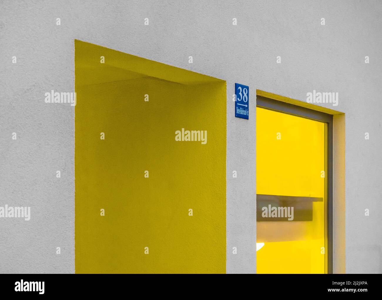 A shot of two yellow lighted rooms with a street sign Stock Photo - Alamy
