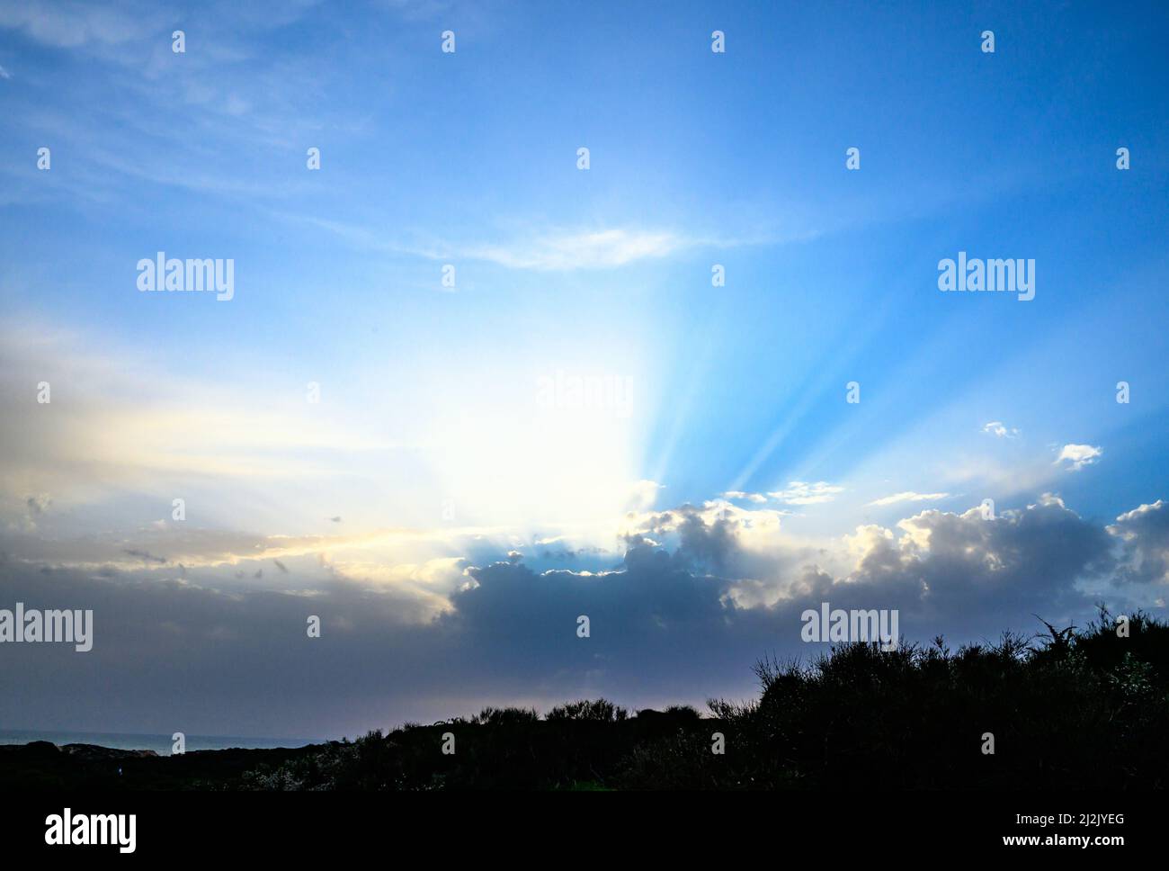The sun's rays behind the cumulus clouds. High resolution Stock Photo - Alamy