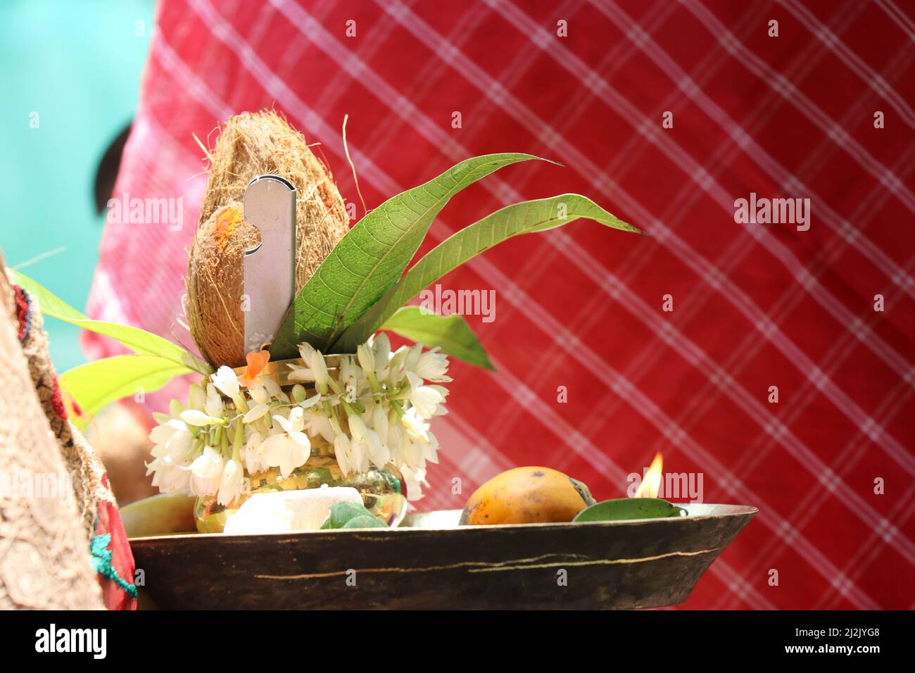 Brass plate with a small coconut placed on its top with some leaves as ...