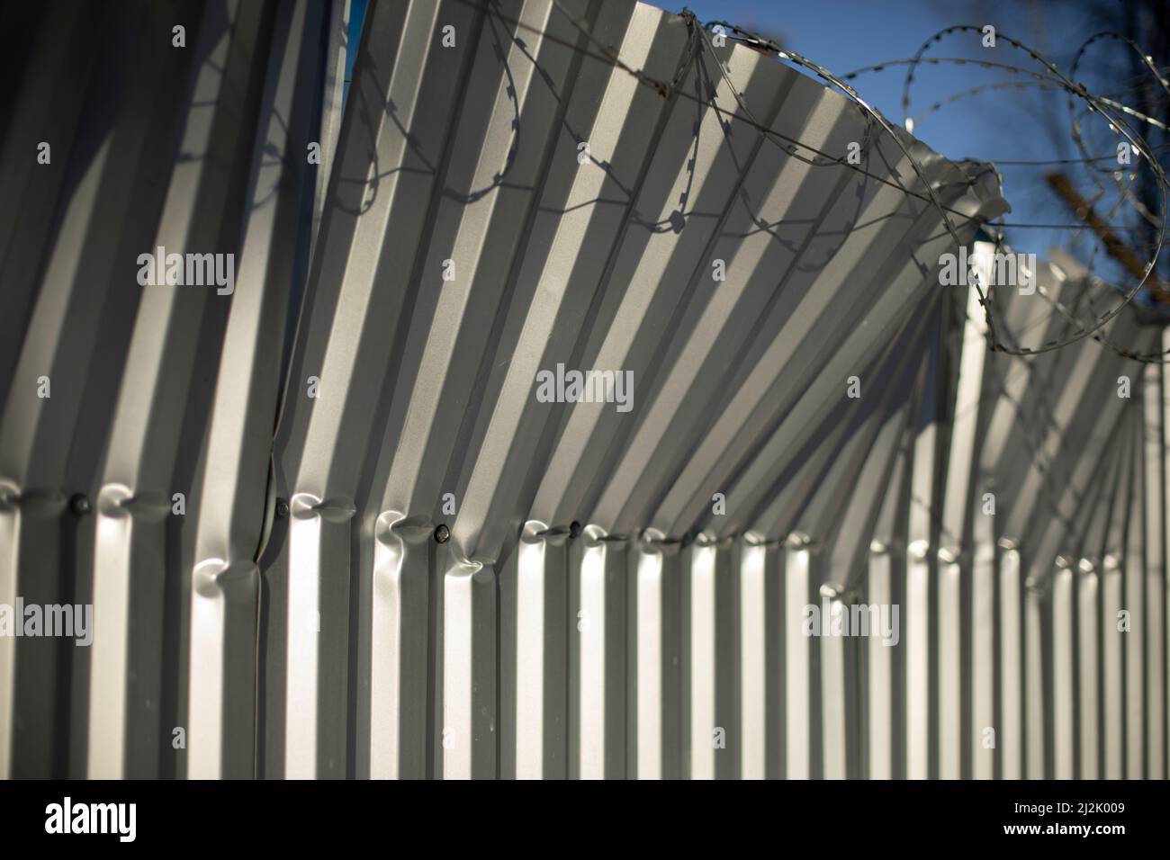 Broken fence. Fence from profile sheet bent. Rumpled iron. Damage to ...