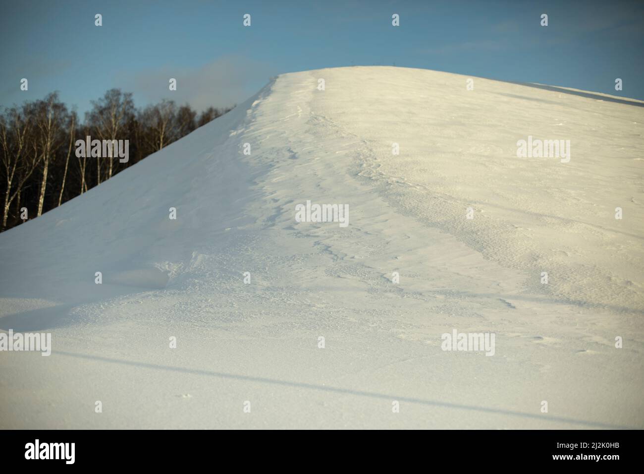 Mountain of snow. Snowy slope. Winter day. Sun is shining on hill ...