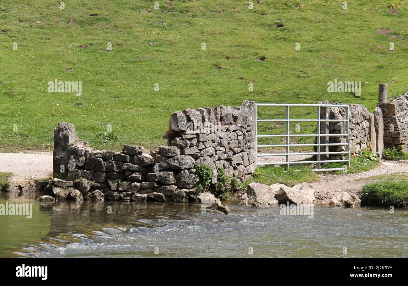 A Pathway Metal Gate in a Dry Stone Wall by a River Stock Photo - Alamy