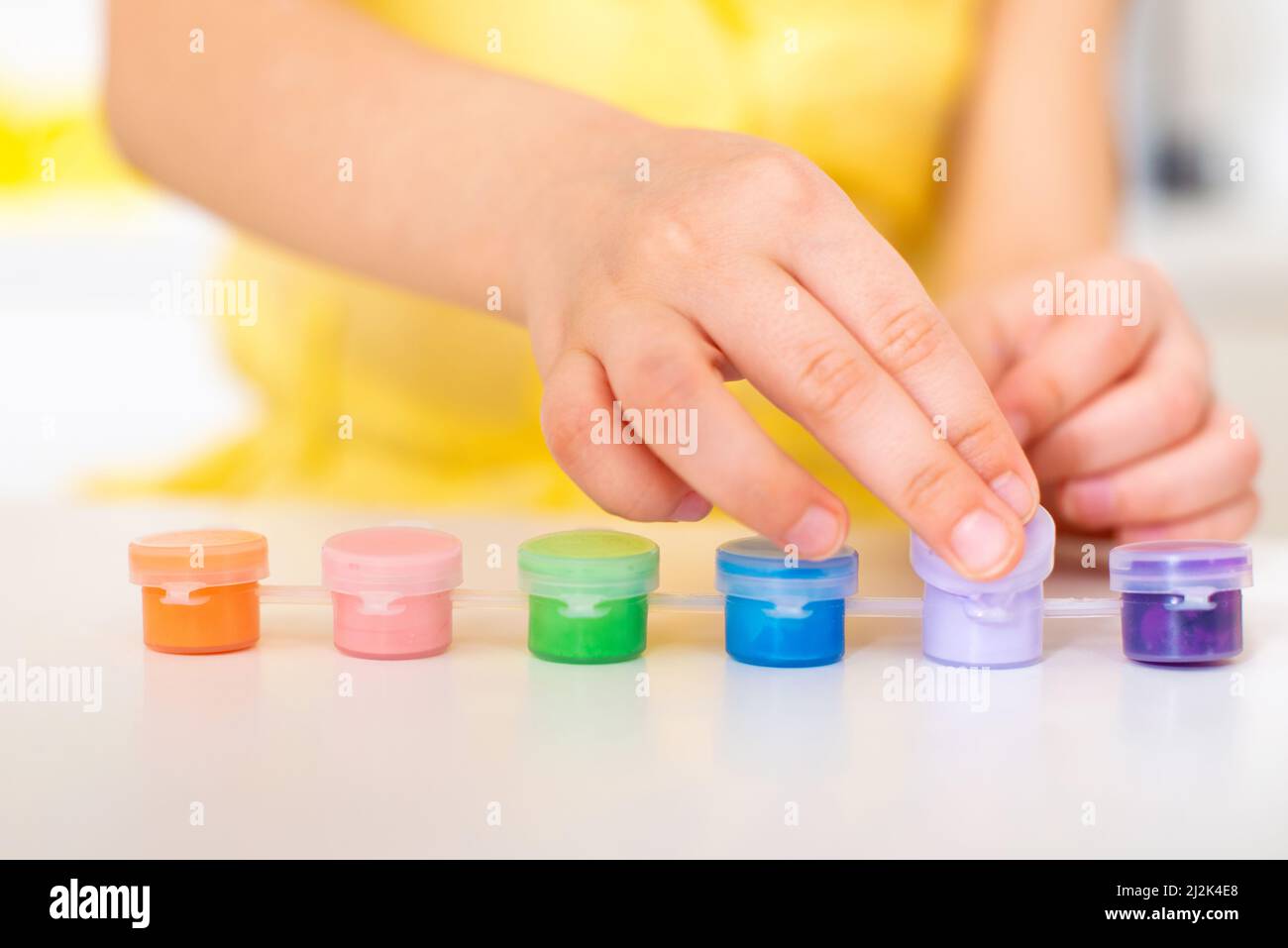 Close-up of children's hands with multi-colored tubes of finger or ...