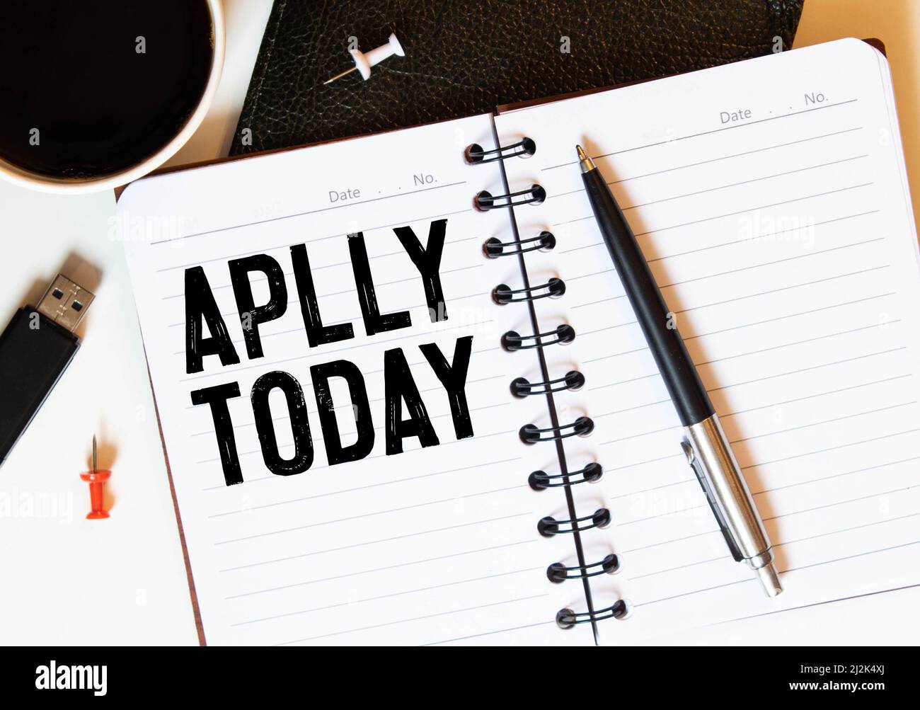 Aplly today text written in notebook on a wooden table. View from above ...