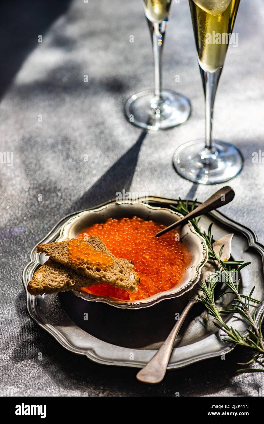 Overhead view of a spoonful of red trout caviar and toast with two ...