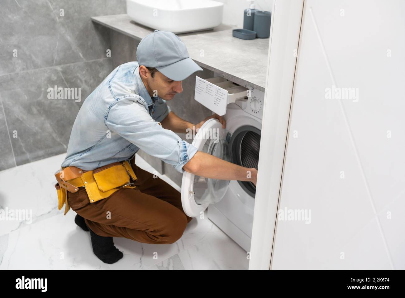 Plumber repairing washing machine hi-res stock photography and images ...