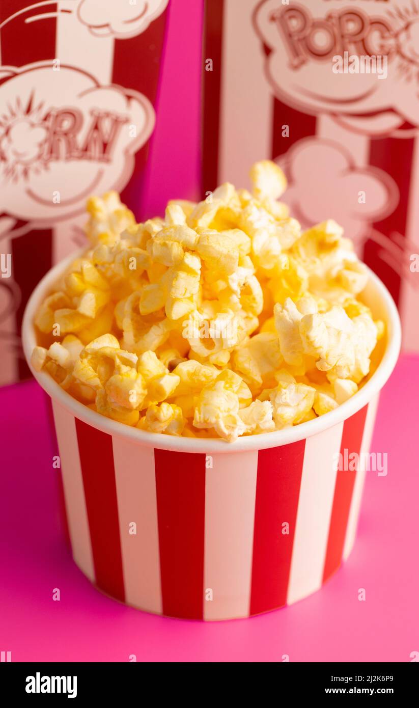 Red and White Striped Popcorn Bucket Isolated on a Pink Background ...