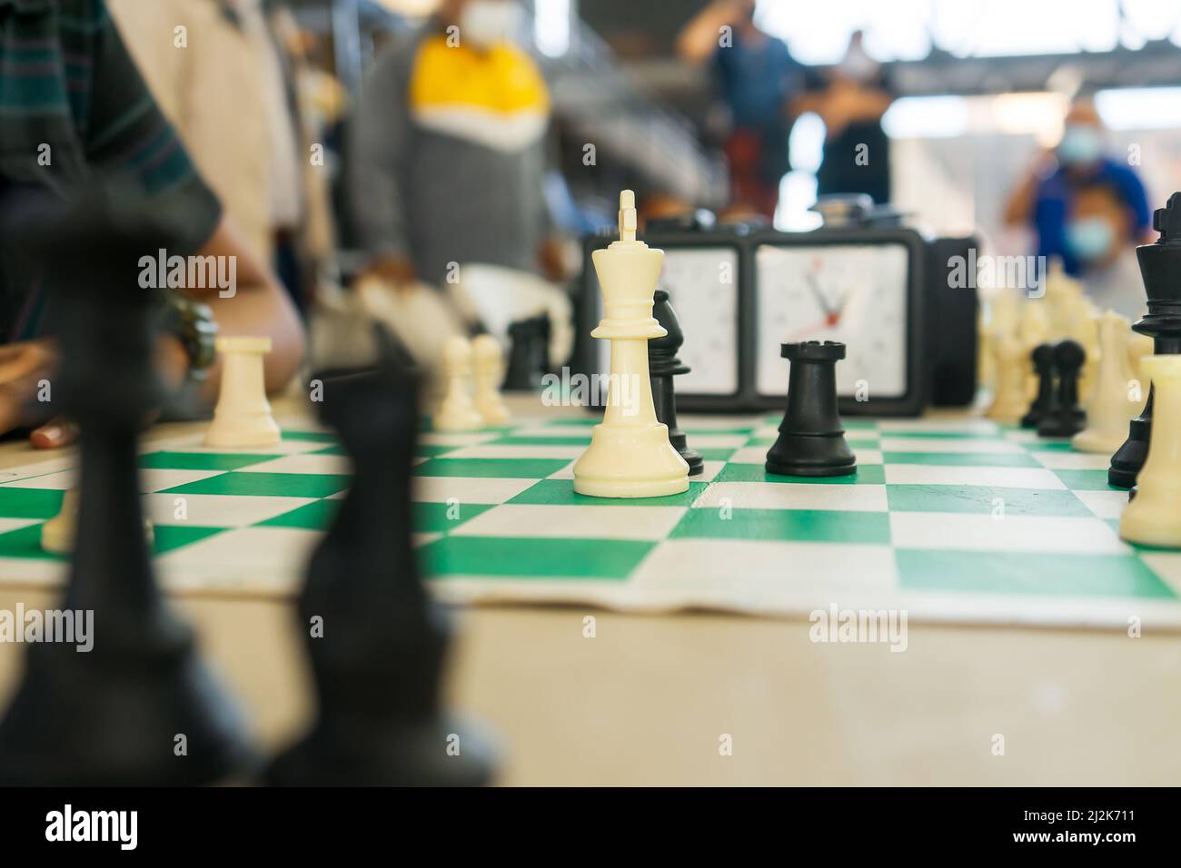 The king piece of a chess board stands alone in the center while a ...