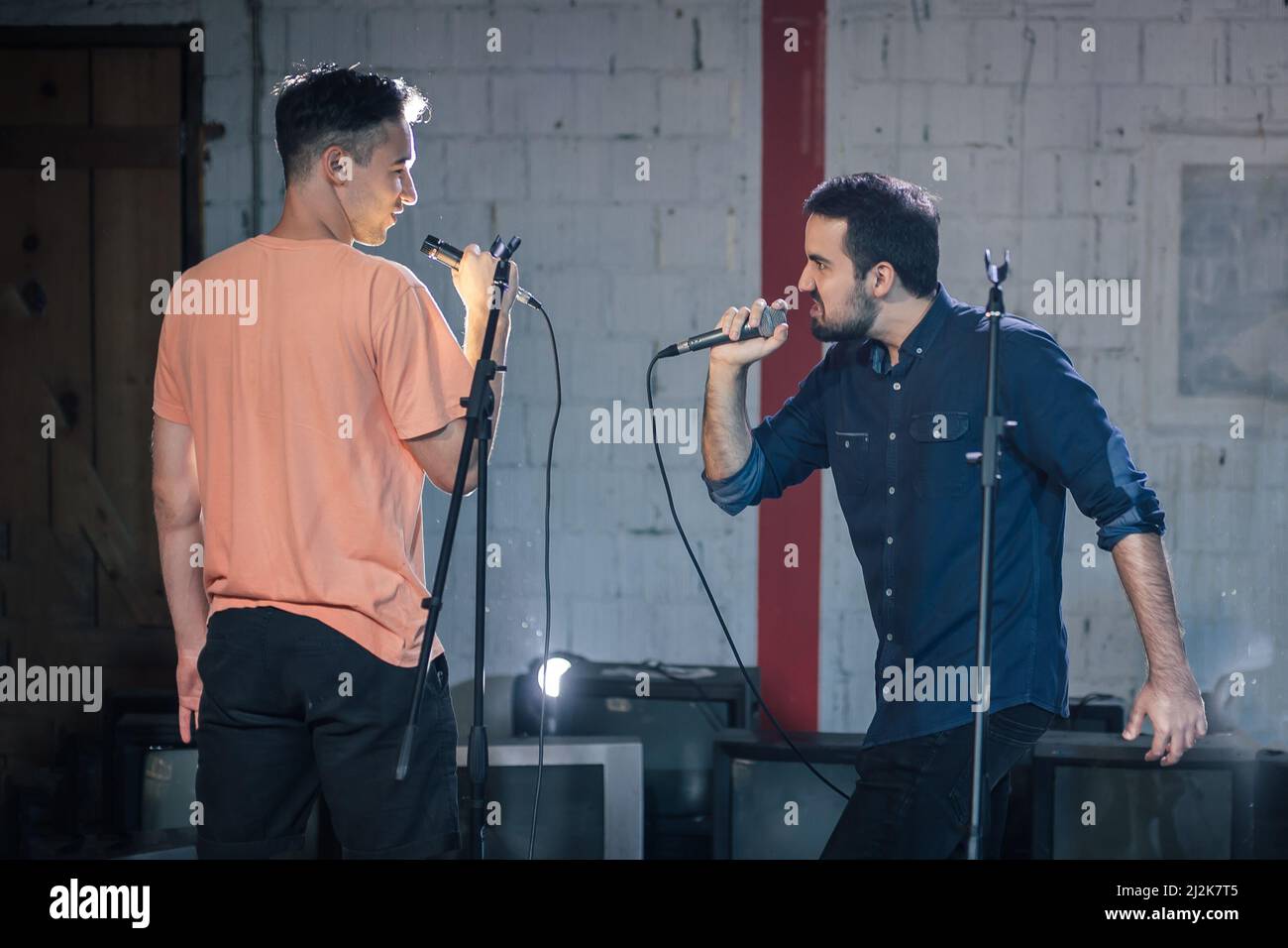 Smiling and witty stand up actor comedian on stage, talking and singing ...