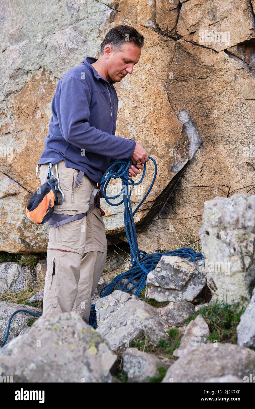 Mountaineer preparing ropes for climbing in mountains Stock Photo - Alamy