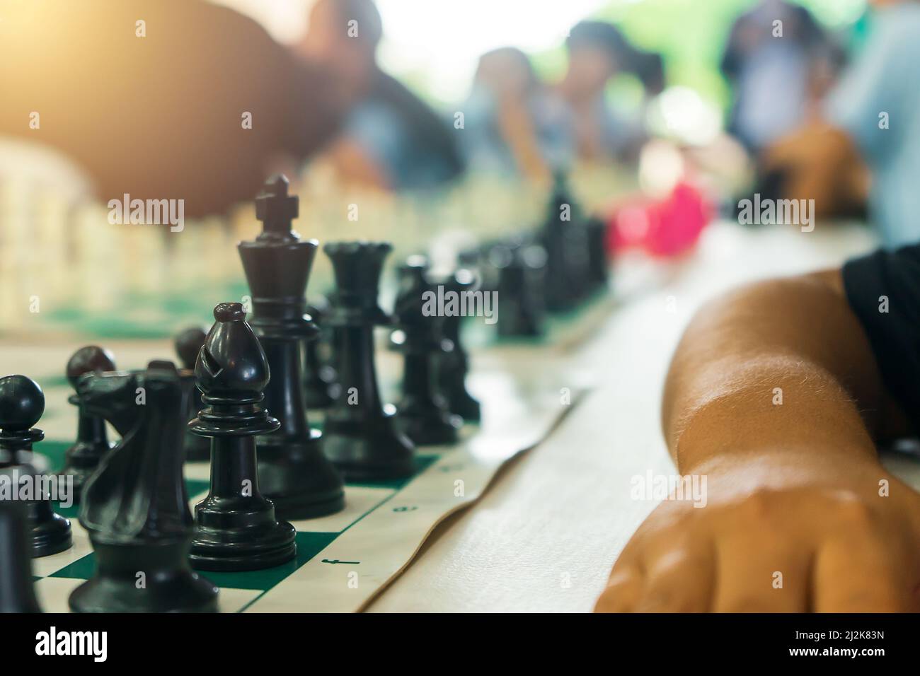 Closeup of the arm of a Latin boy who selected the team of black pieces ...