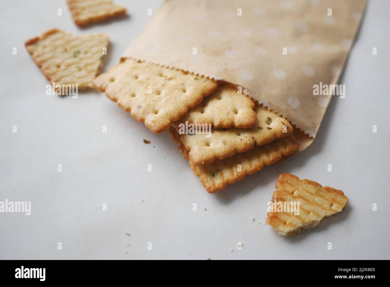 close up of sweet cookies spilling form a paper packet on table Stock ...