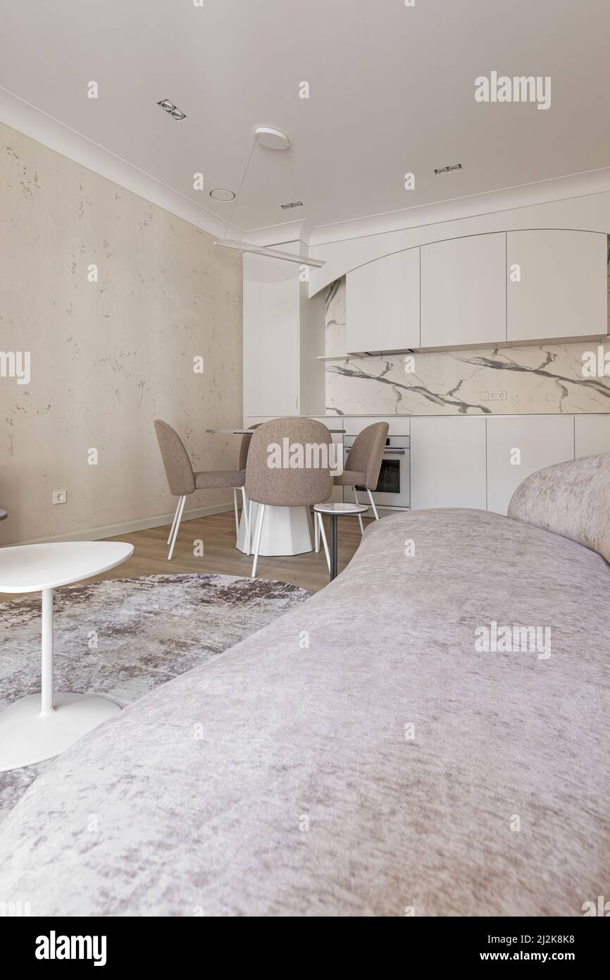 Modern living room interior in pastel colours with round dining table ...