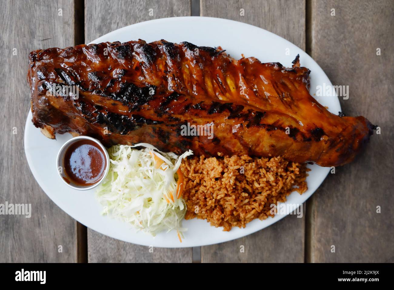 HOUSE CLASSIC RIBS AND CHICKEN Rice in a dish top view on grey ...